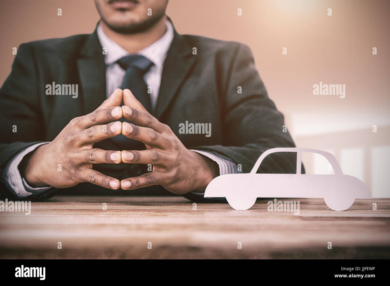 business man sitting behind a desk against bright room with wall in the ...