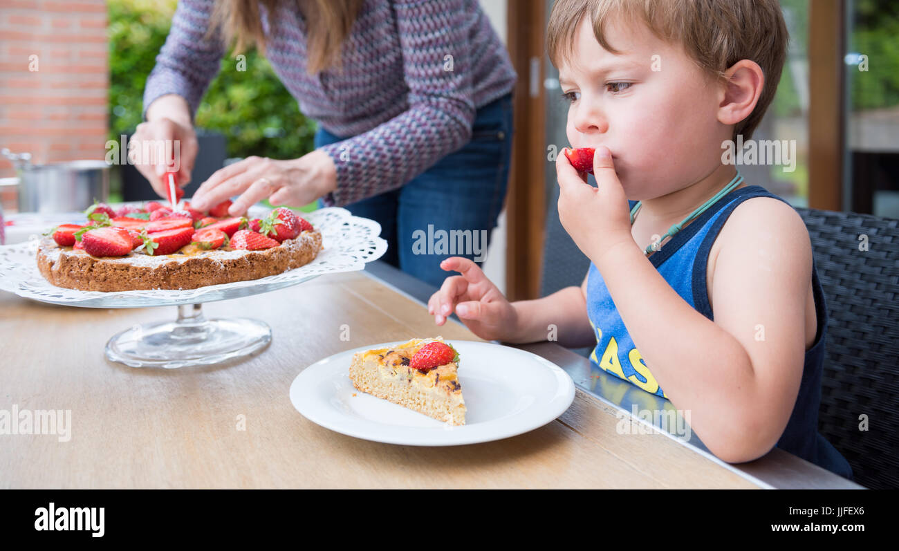 Child eating a slice of strawberry cake Stock Photo - Alamy