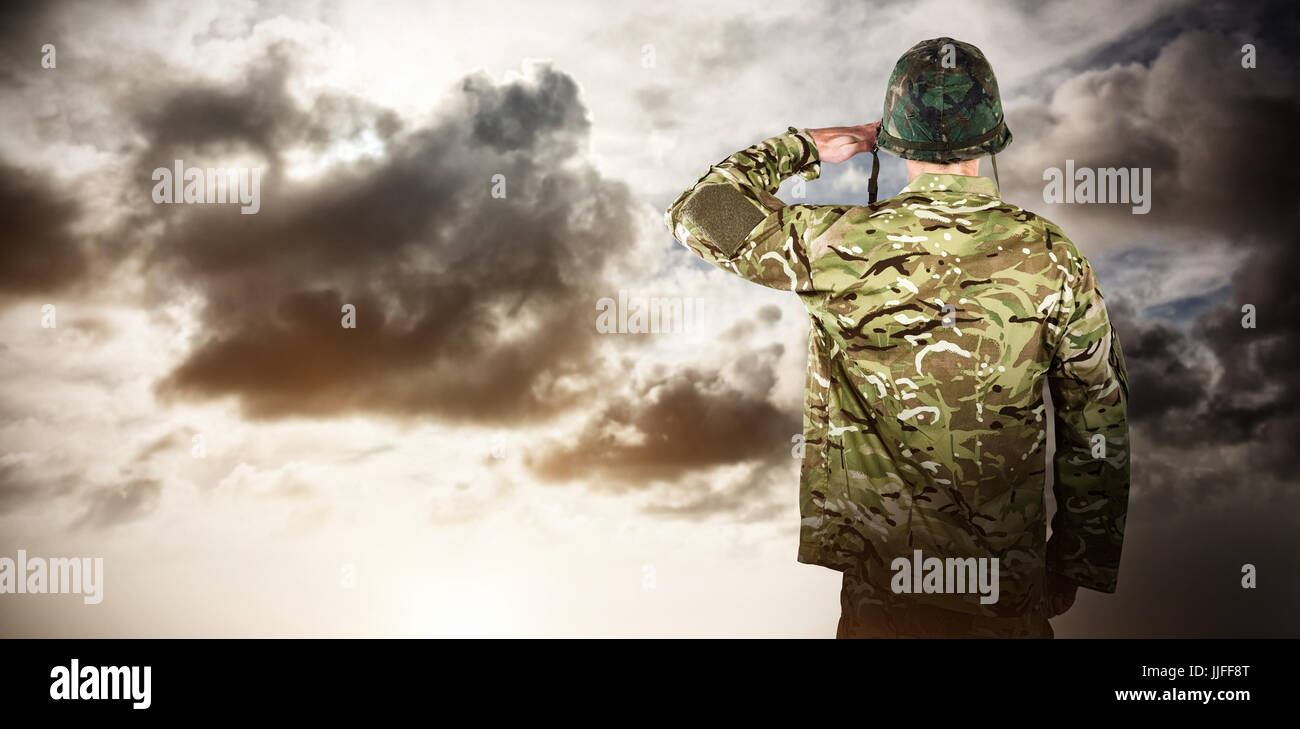 Rear view of military soldier saluting against blue sky with white ...