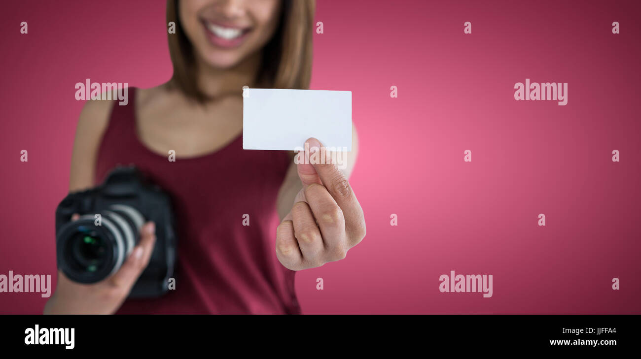 Happy woman showing identity card while holding camera against red and ...