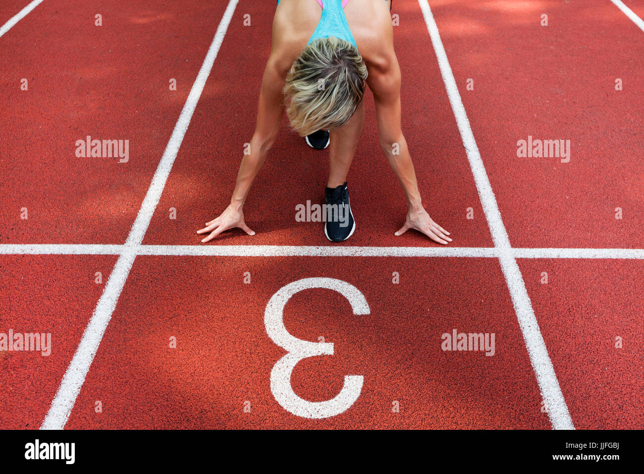 Athlete on starting line waiting for the start in running track Stock ...