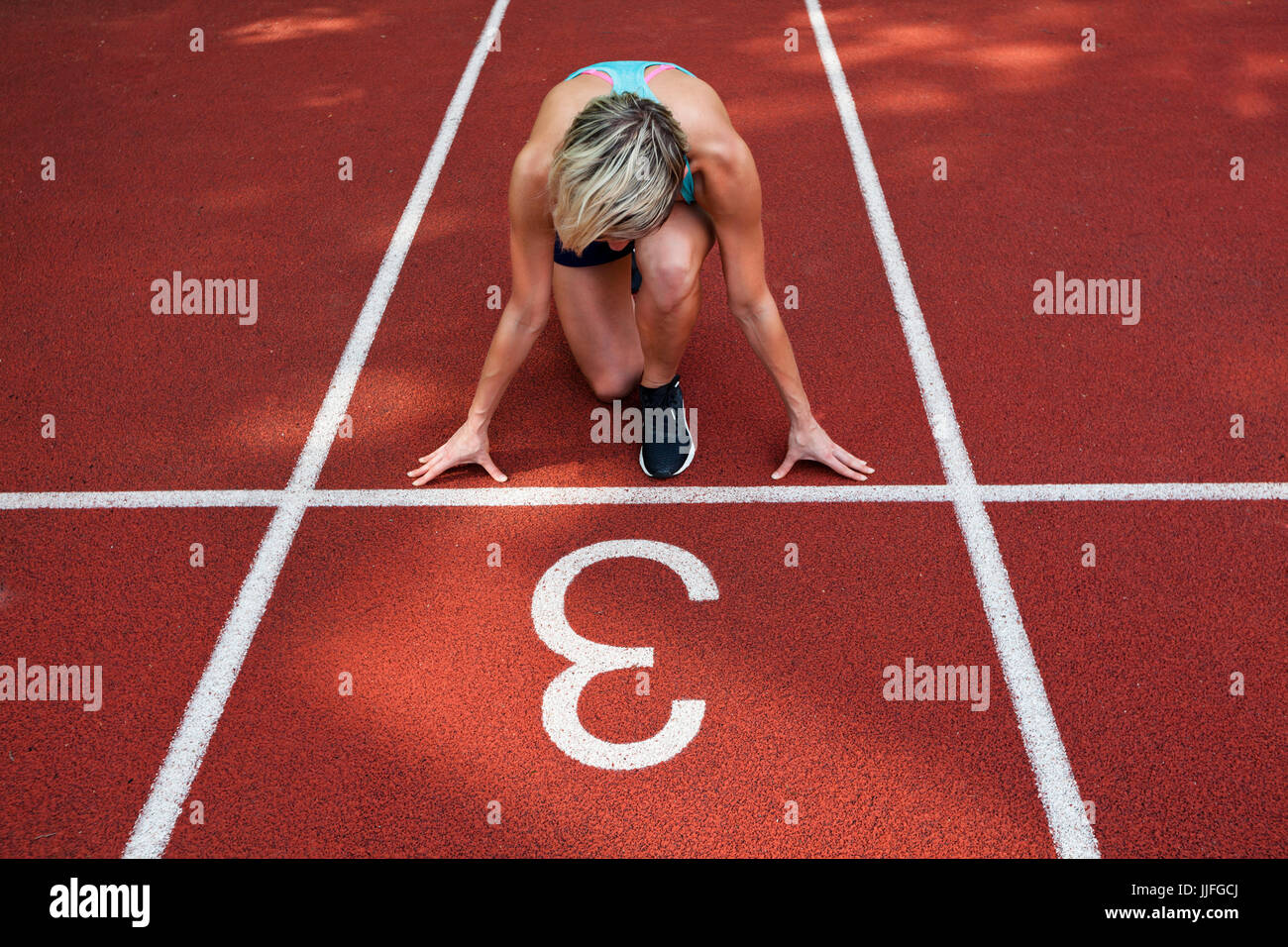 Athlete on starting line waiting for the start in running track Stock ...
