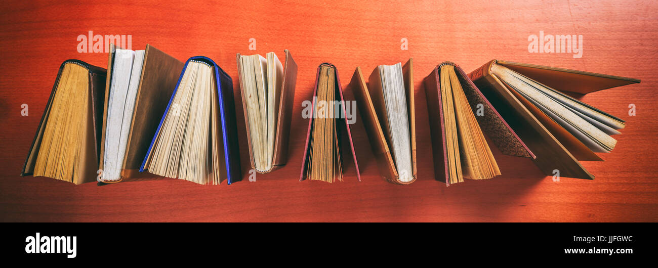 Old books standing in row on wooden background - banner Stock Photo - Alamy