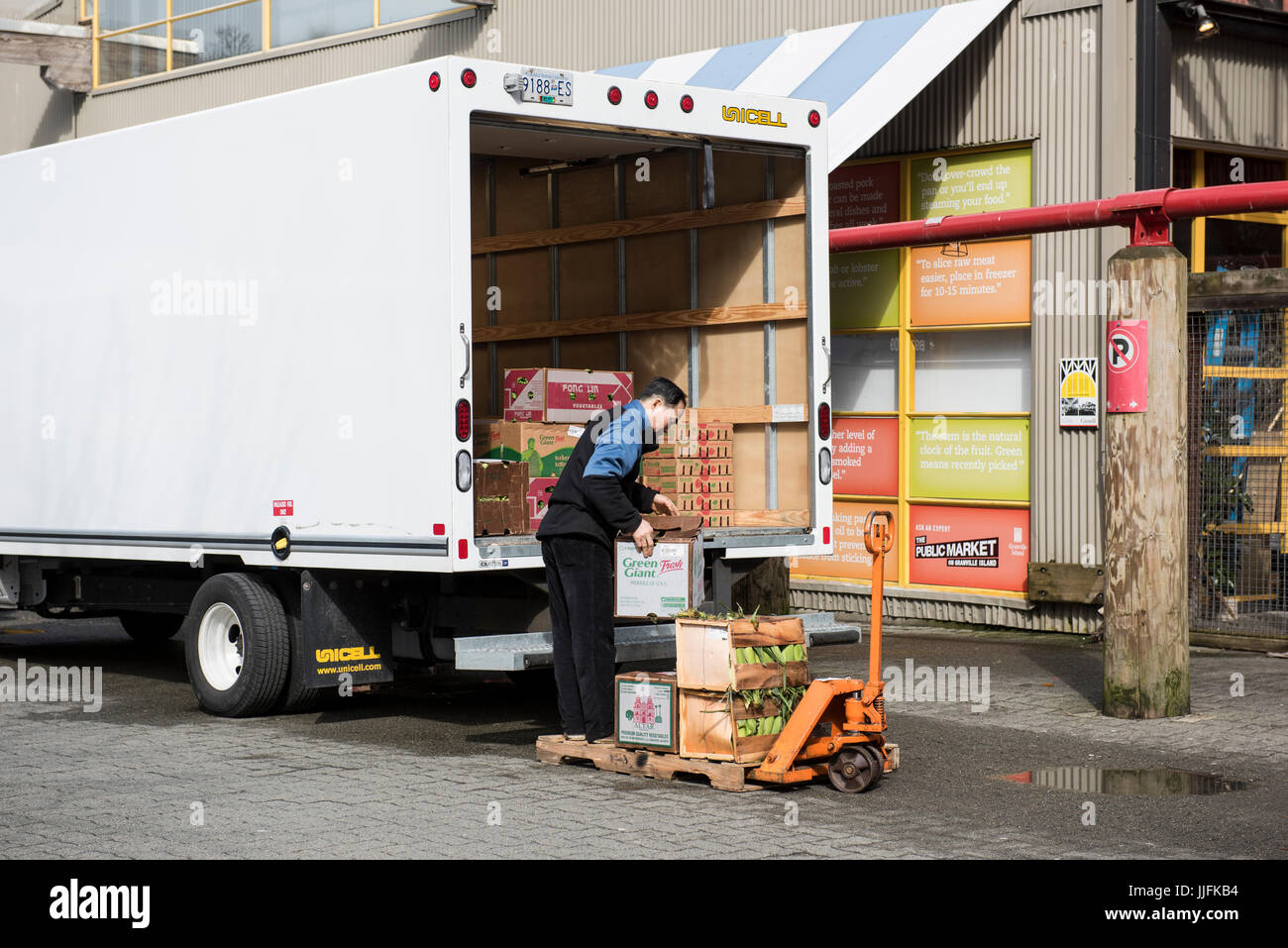 Man unloading produce from the back of a truck Stock Photo - Alamy