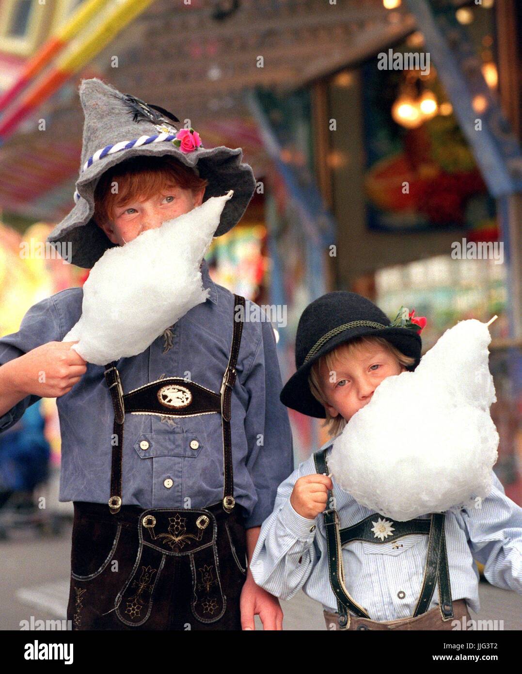 Children in traditional clothing are eating cotton candy at the ...