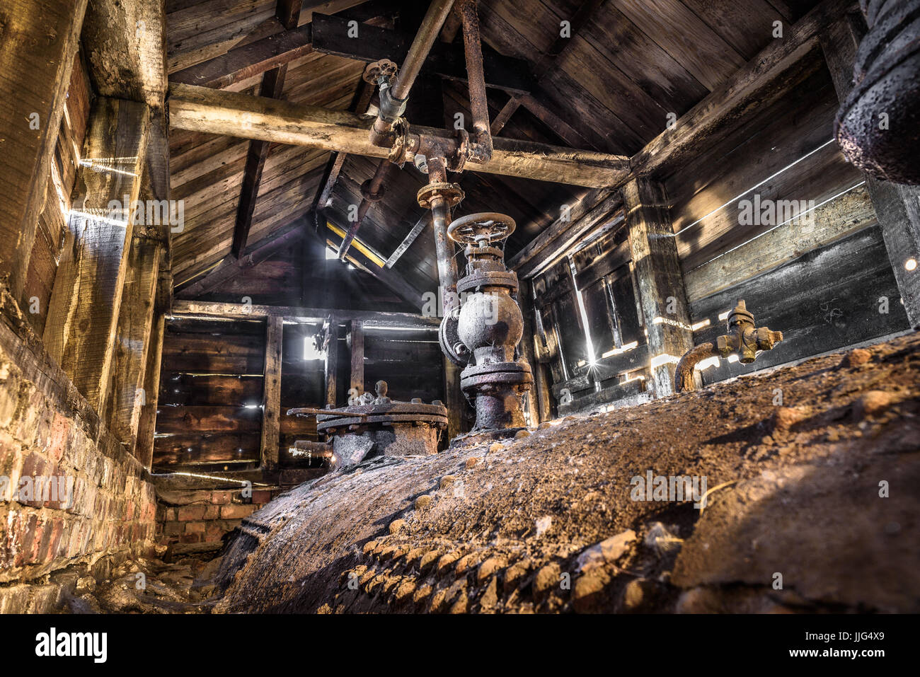 An old, abandoned steam boiler in timber framed shed Stock Photo ...