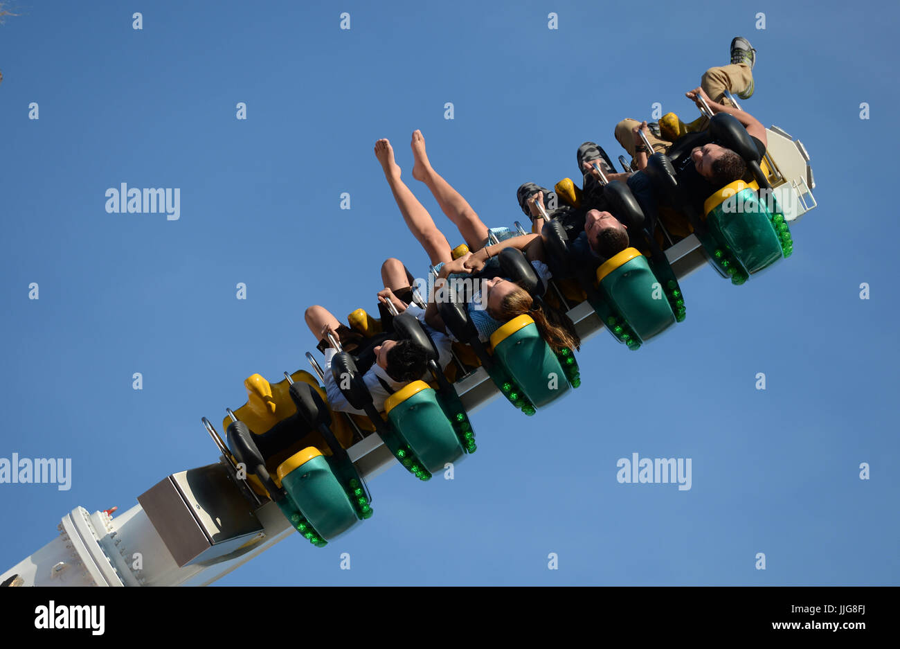 A woman rides a carnival ride and stretches her legs out at Oktoberfest ...