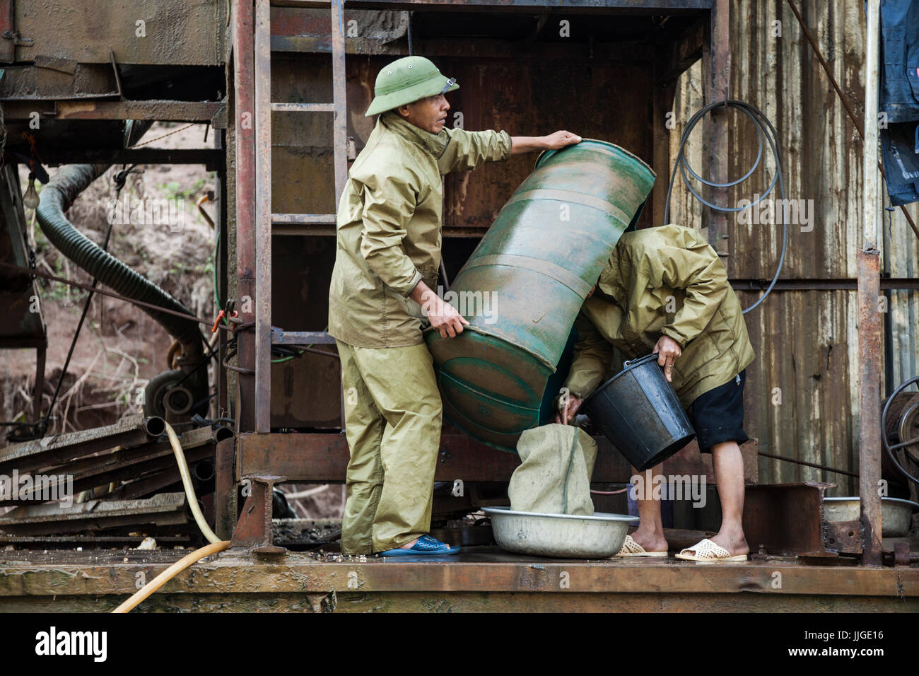 Vietnamese men empty out concentrate from the sluice box into a bag for ...