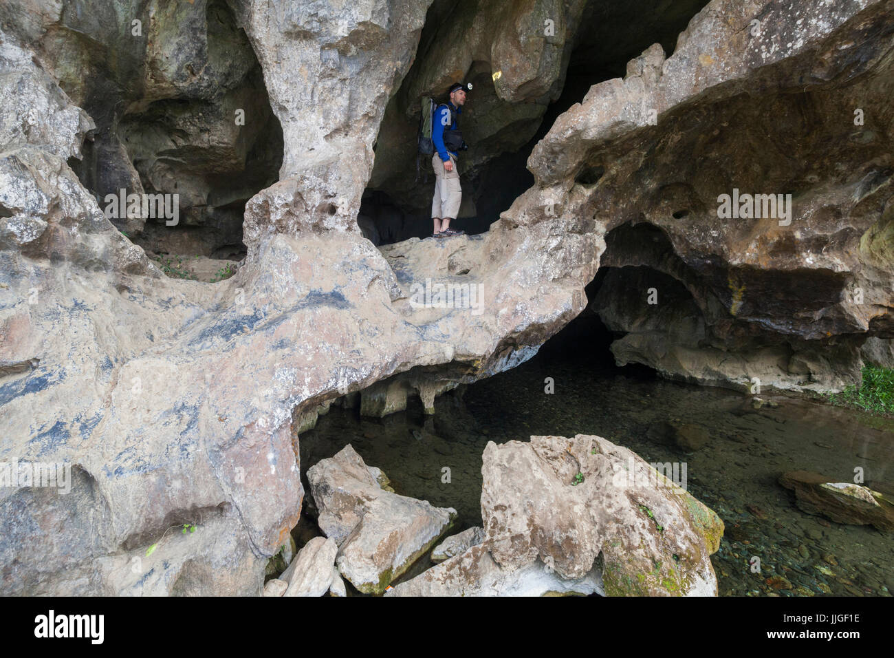 Side view of man exploring natural limestone cave hi-res stock ...