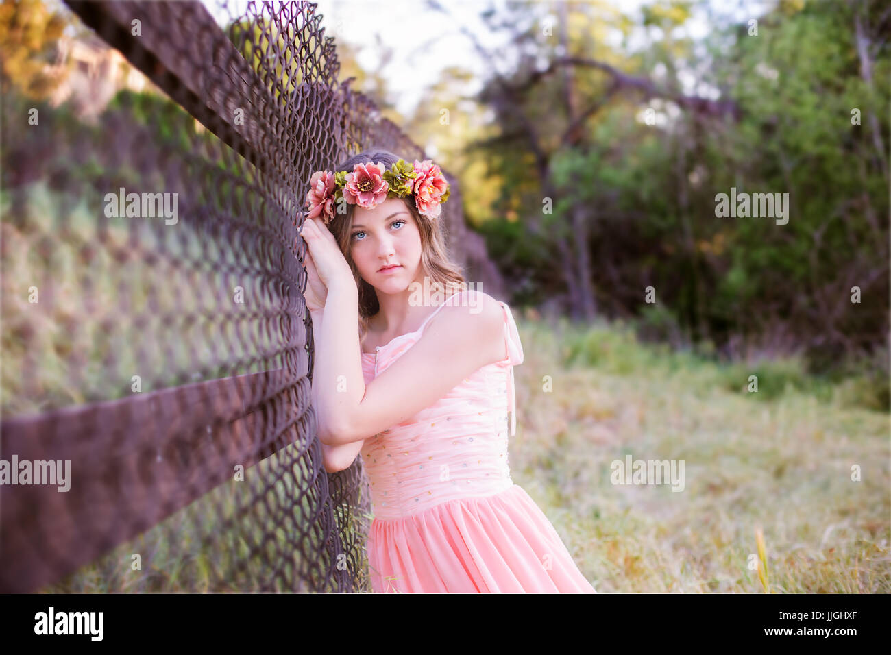 Portrait of a teenage girl leaning against a fence, California, USA ...