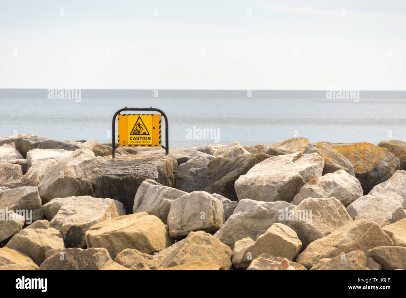 Warning sign set on the stones on the sea front Stock Photo - Alamy