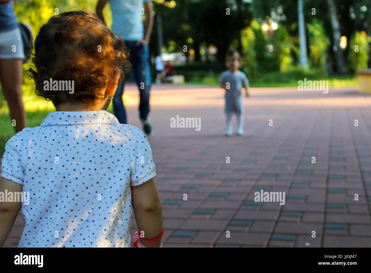 Two little girls stare at each other in the park Stock Photo - Alamy