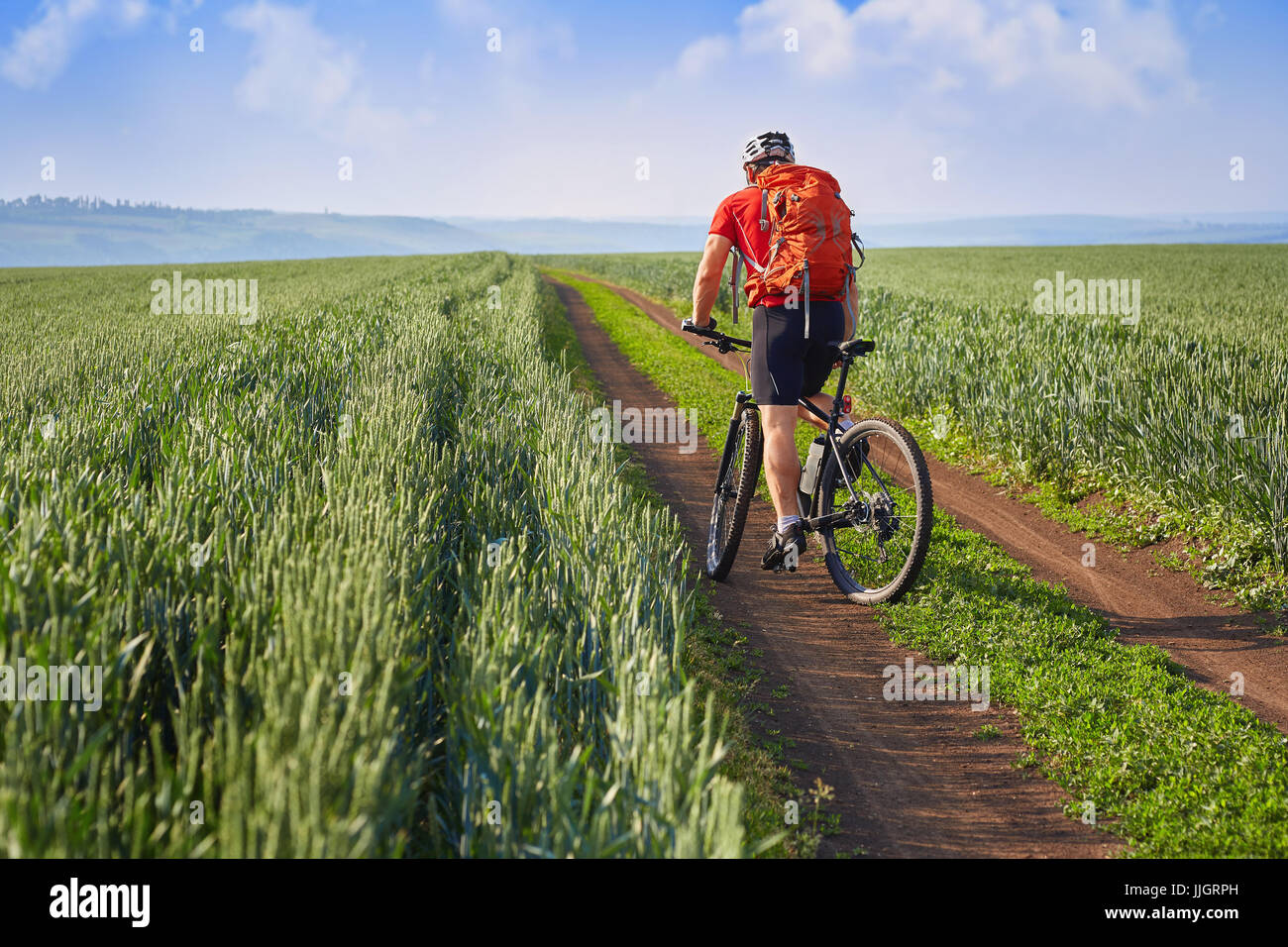Traveler with backpack Riding the Bike on the Beautiful Spring Mountain ...