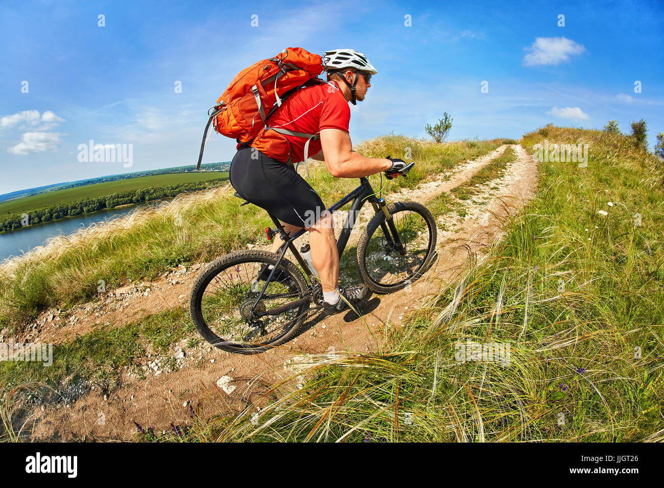 Traveler with backpack Riding the Bike on the Beautiful Spring Mountain ...