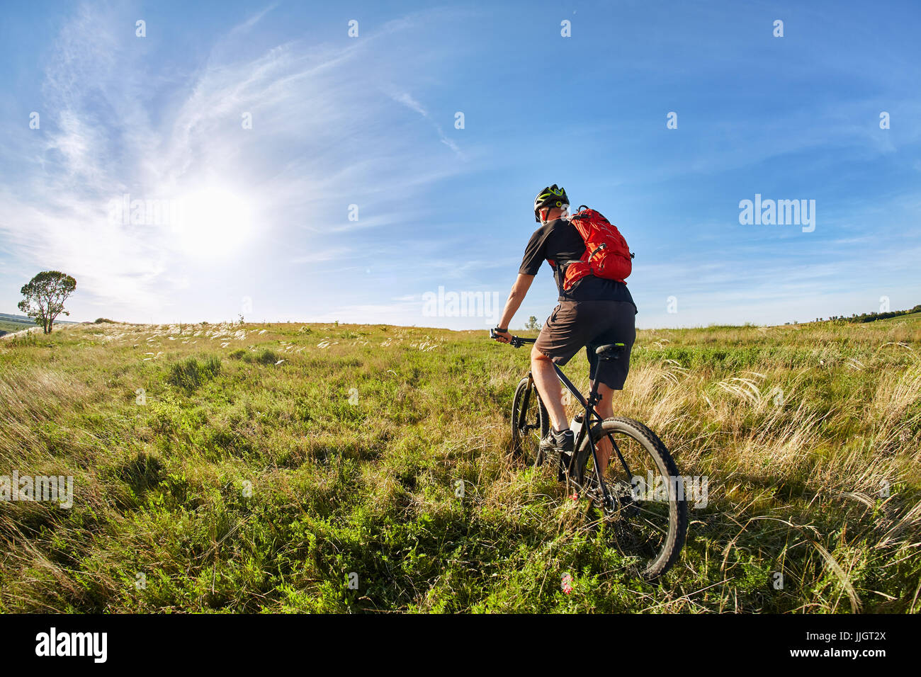 Traveler with backpack Riding the Bike on the Beautiful Spring Mountain ...
