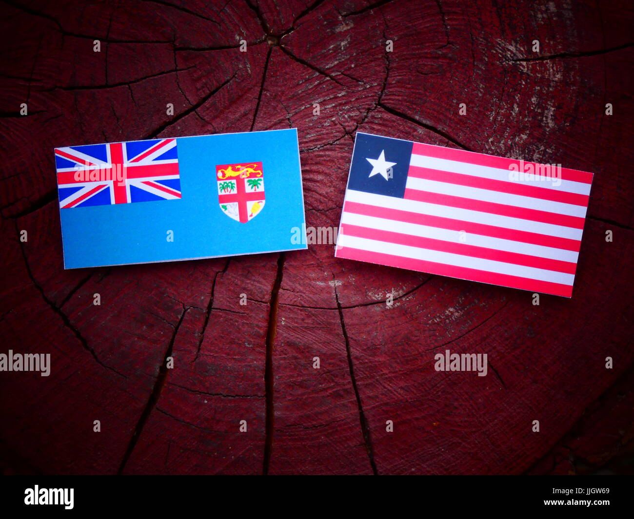 Fijian flag with Liberian flag on a tree stump isolated Stock Photo - Alamy
