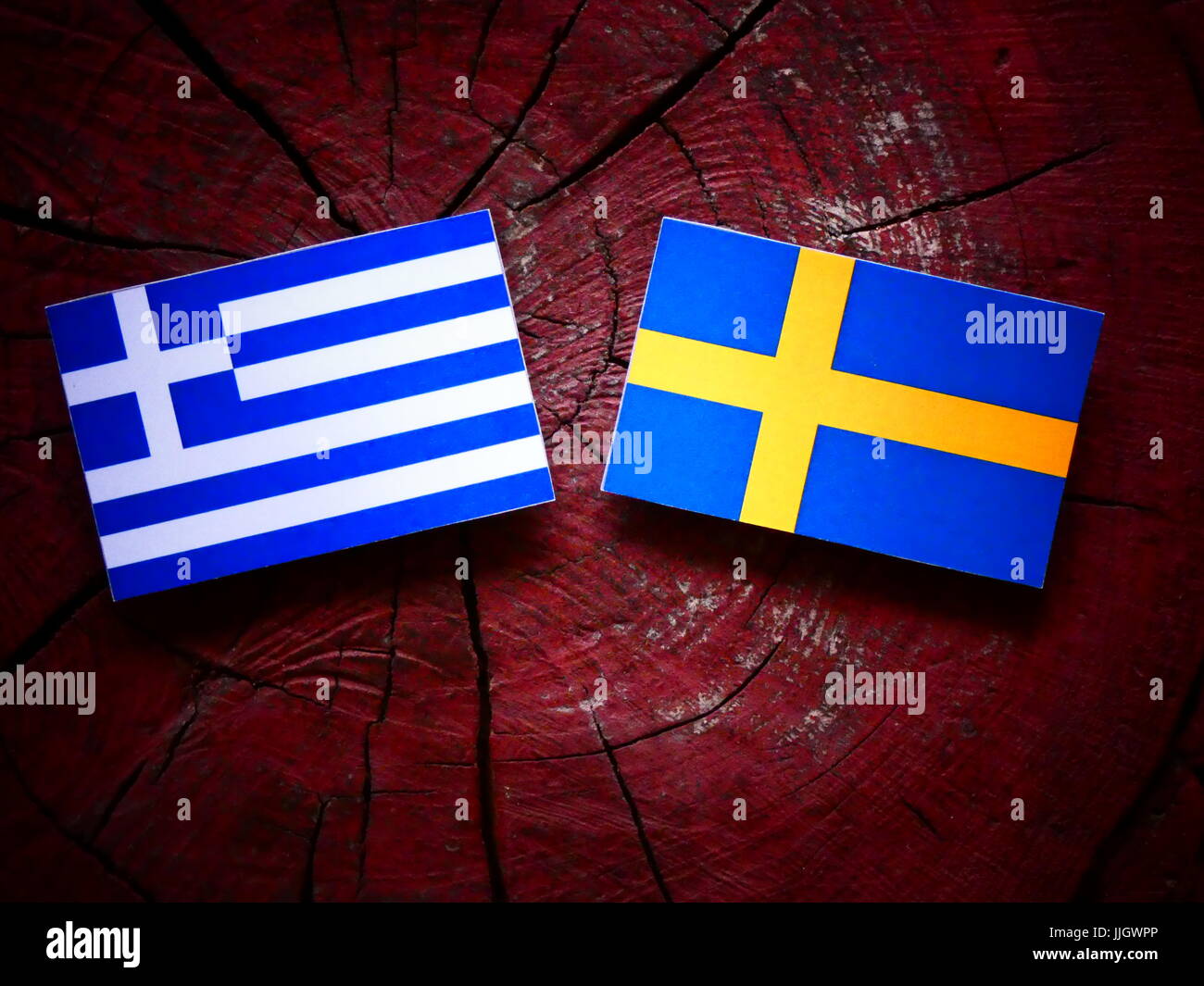Greek flag with Swedish flag on a tree stump isolated Stock Photo - Alamy