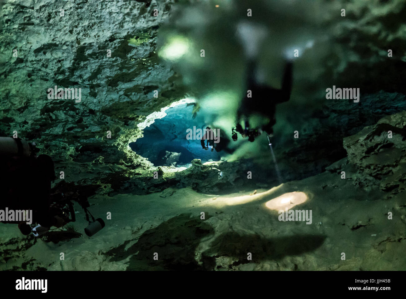 A scuba diver stands at the entrance of Tajma Ha cenote in Mexico's ...