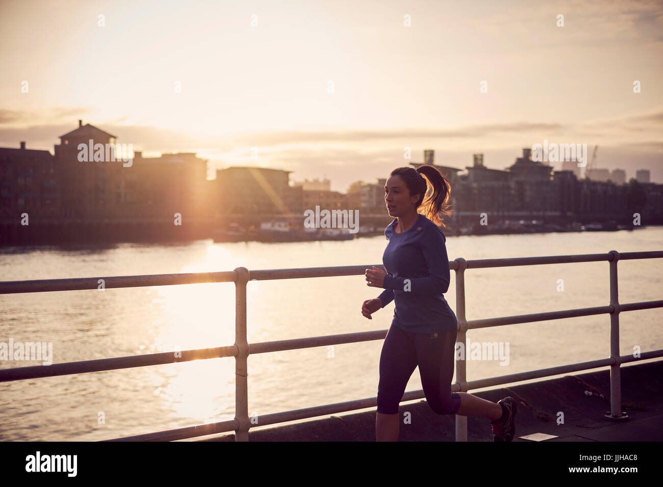 A woman running alongside the River Thames in London Stock Photo - Alamy