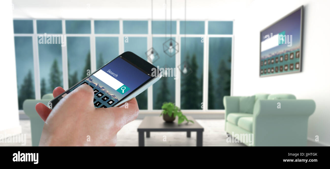 Close-up of hand holding mobile phone against blue sofas on floor in ...