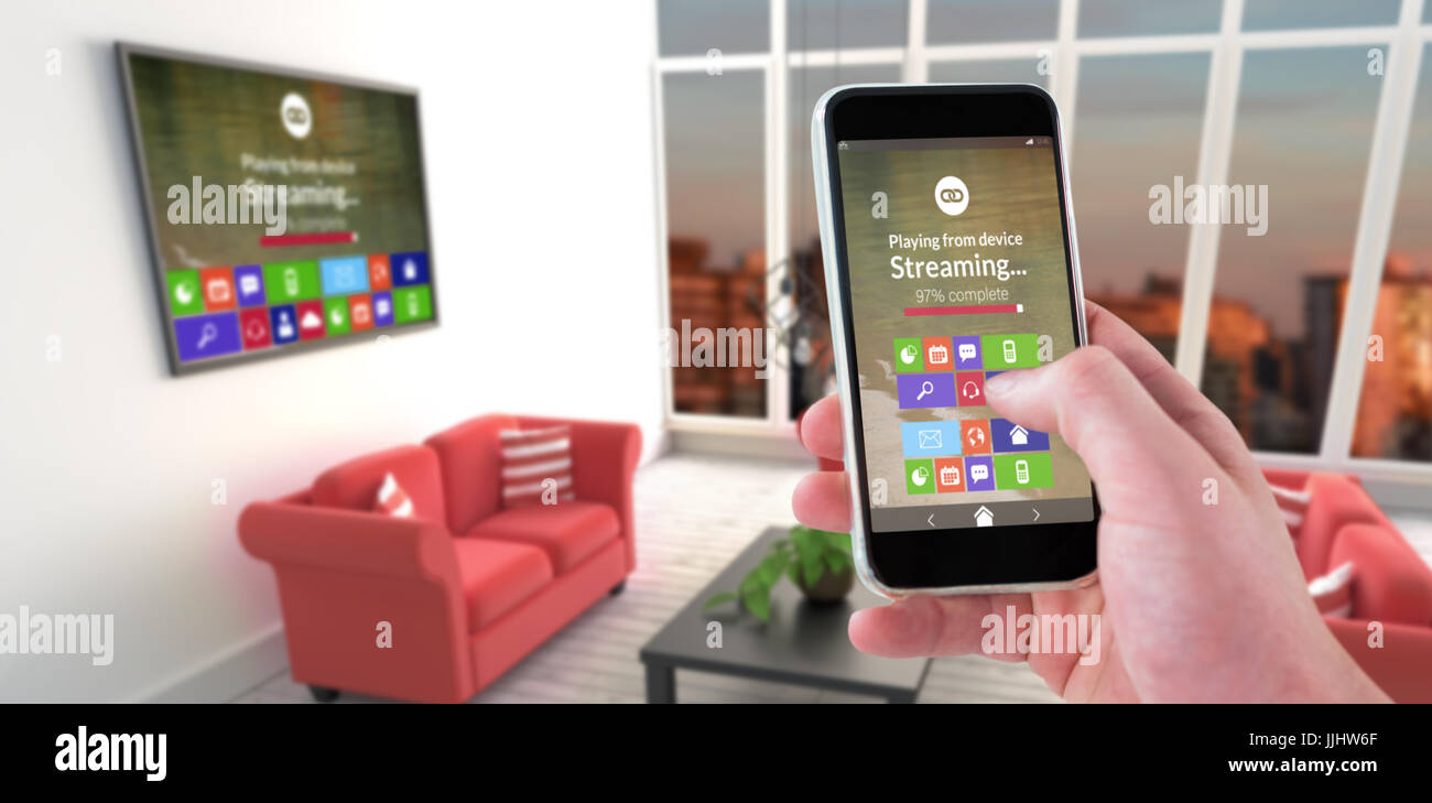 Cropped hand using mobile phone against red sofas in living room at ...