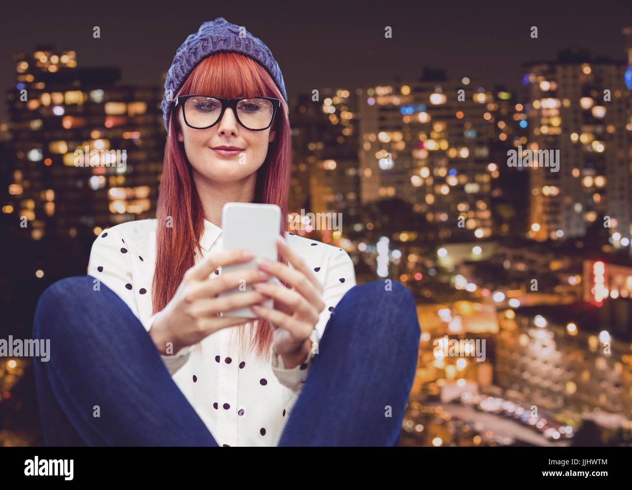 Smiling woman texting with a city in background Stock Photo - Alamy