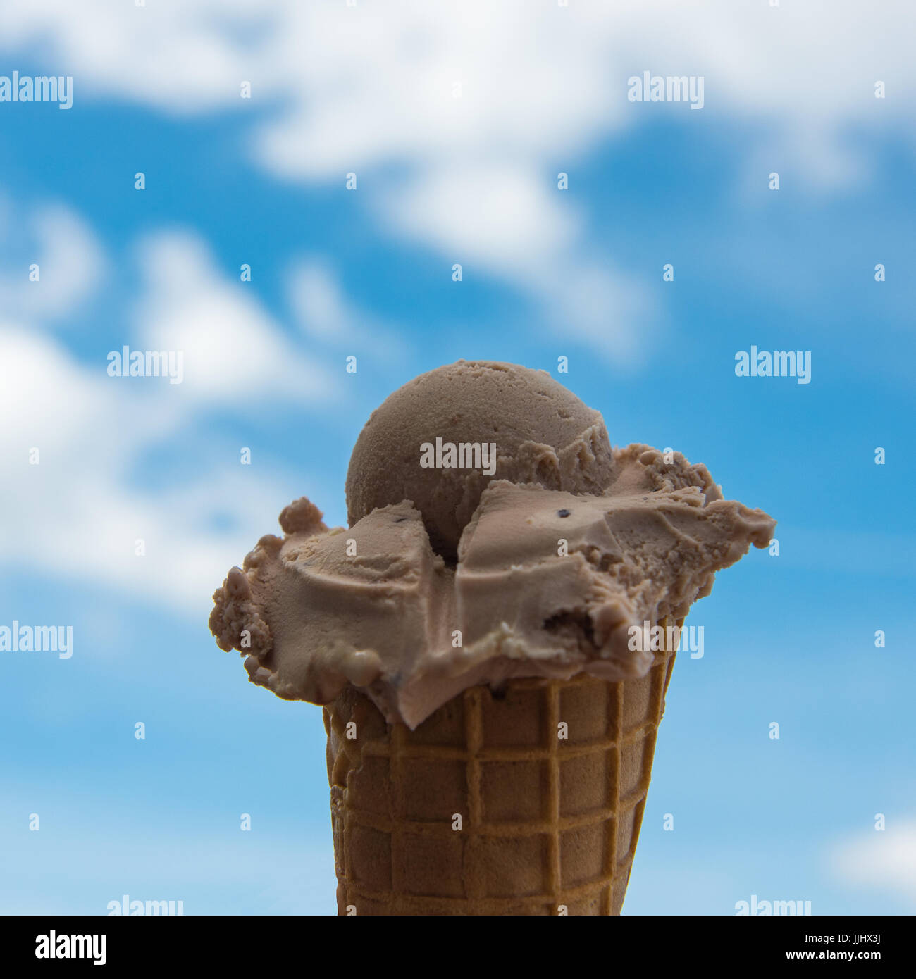 Scoop of ice in cone, close up against blue sky with clouds Stock Photo ...