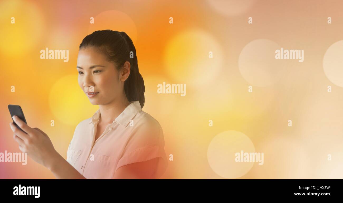 Smiling woman texting in colored lights background Stock Photo - Alamy