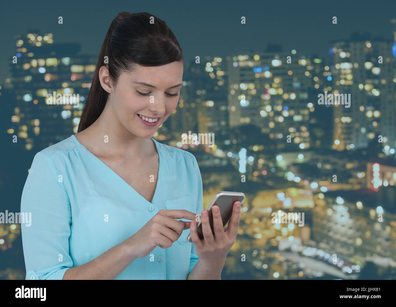 Smiling woman texting against a city on background Stock Photo - Alamy