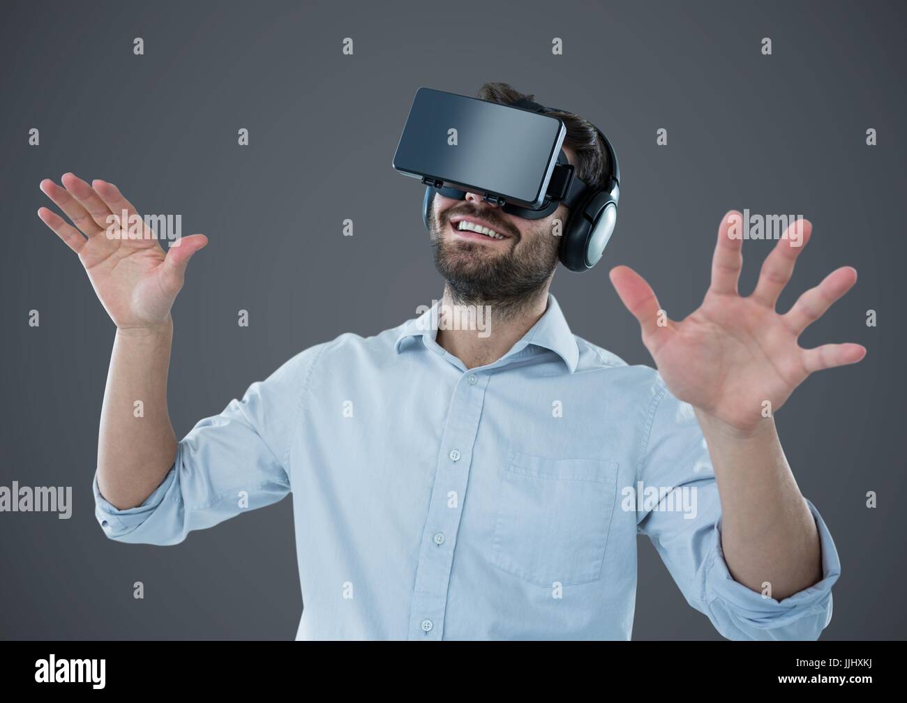 Man in virtual reality headset against grey background Stock Photo - Alamy