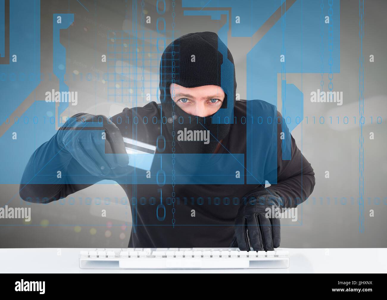 Hacker with credit card using a laptop behind digital screen Stock ...