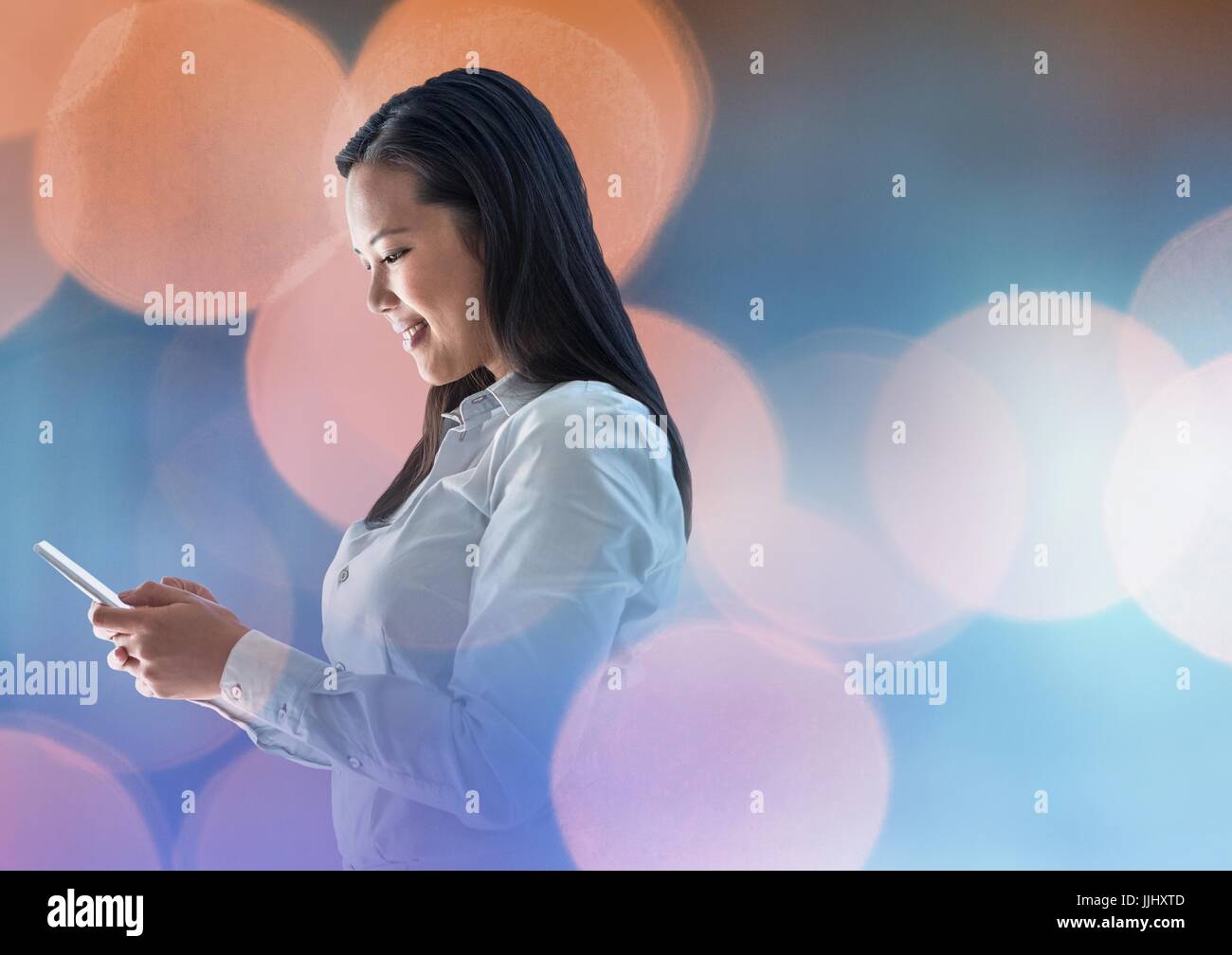 Smiling woman texting in colored lights Stock Photo - Alamy