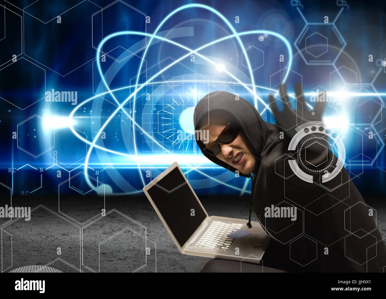 Hacker with sunglasses using a laptop and tending his arm to the lens ...