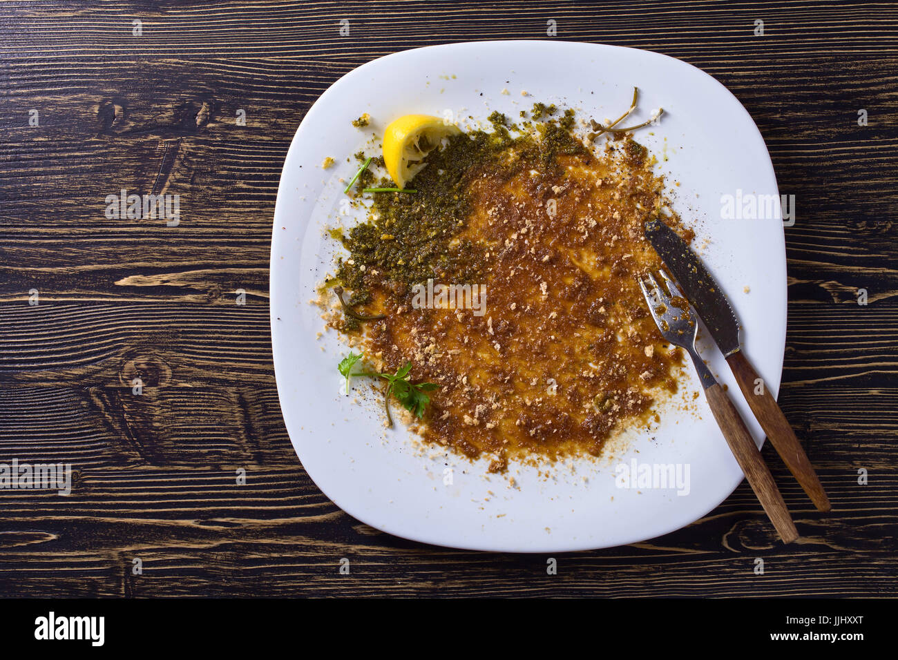 Dirty plate and Cutlery on the wooden table after lunch . The view from ...