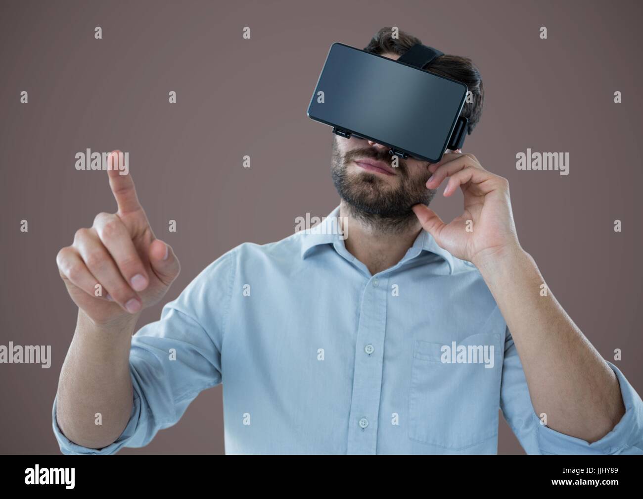Man in virtual reality headset against brown background Stock Photo - Alamy