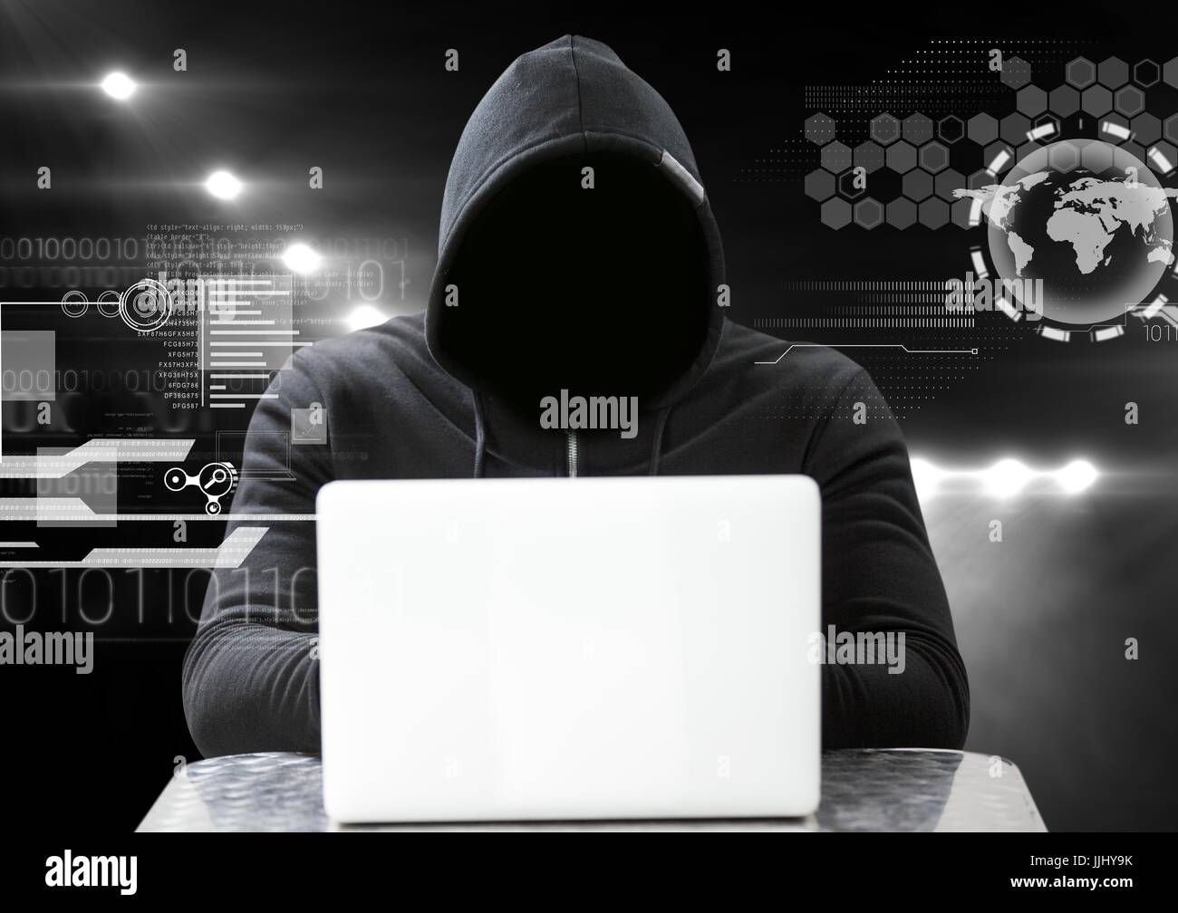 Hacker using a laptop in front of dark background with digital icons ...