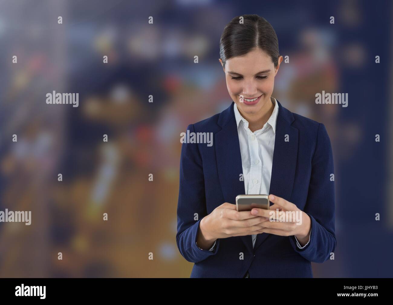 Smiling woman texting against city background Stock Photo - Alamy