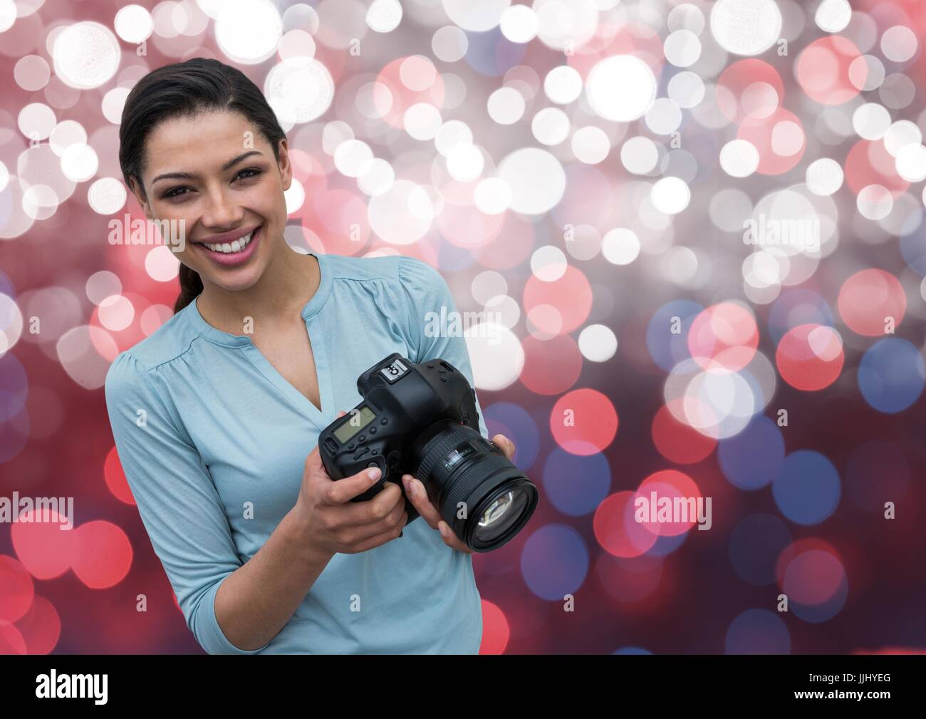happy young photographer with camera on hands. Pink, blue and white ...