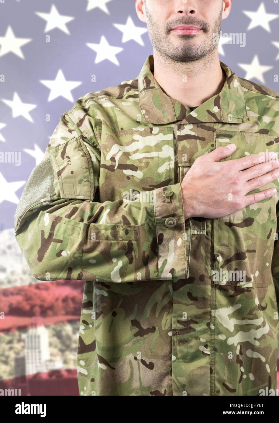 Smiling soldier putting his hand on his heart against american flag ...