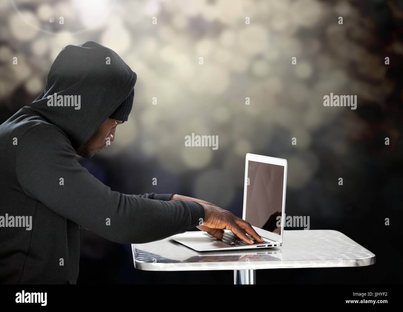 Side view of hacker using a laptop in front of black background Stock ...