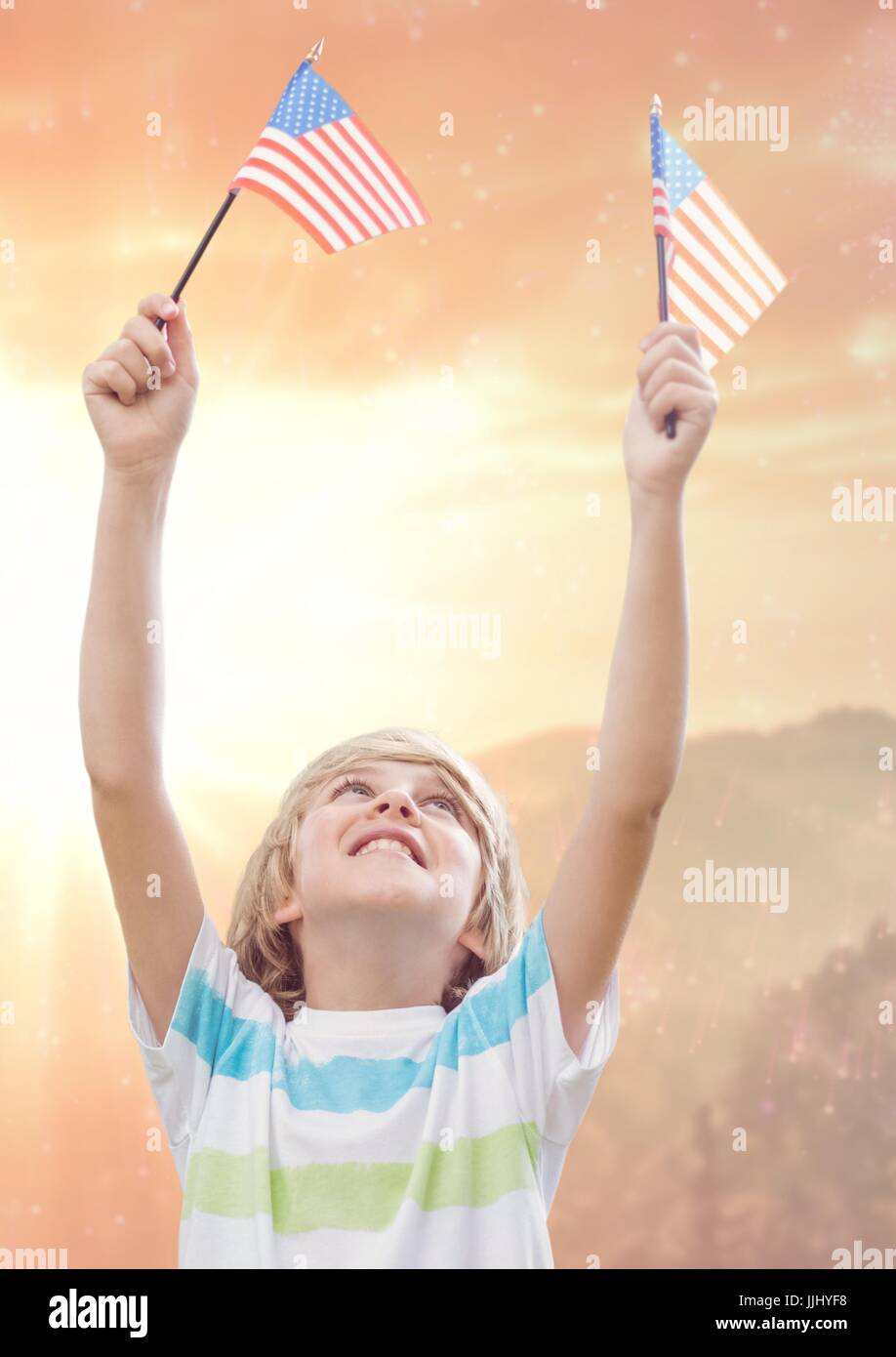 Smiling boy holding american flags against sunny landscape Stock Photo ...