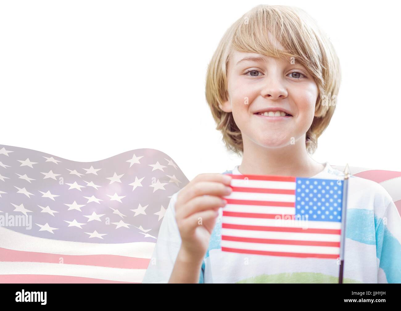 Smiling boy holding an american flag against fluttering american flag ...