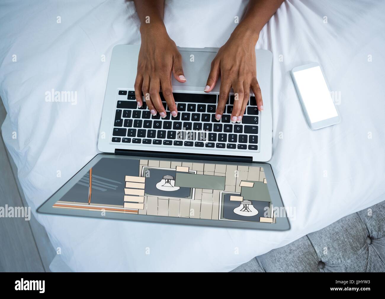 computer with hands on bed. On the screen the design for the wall Stock ...