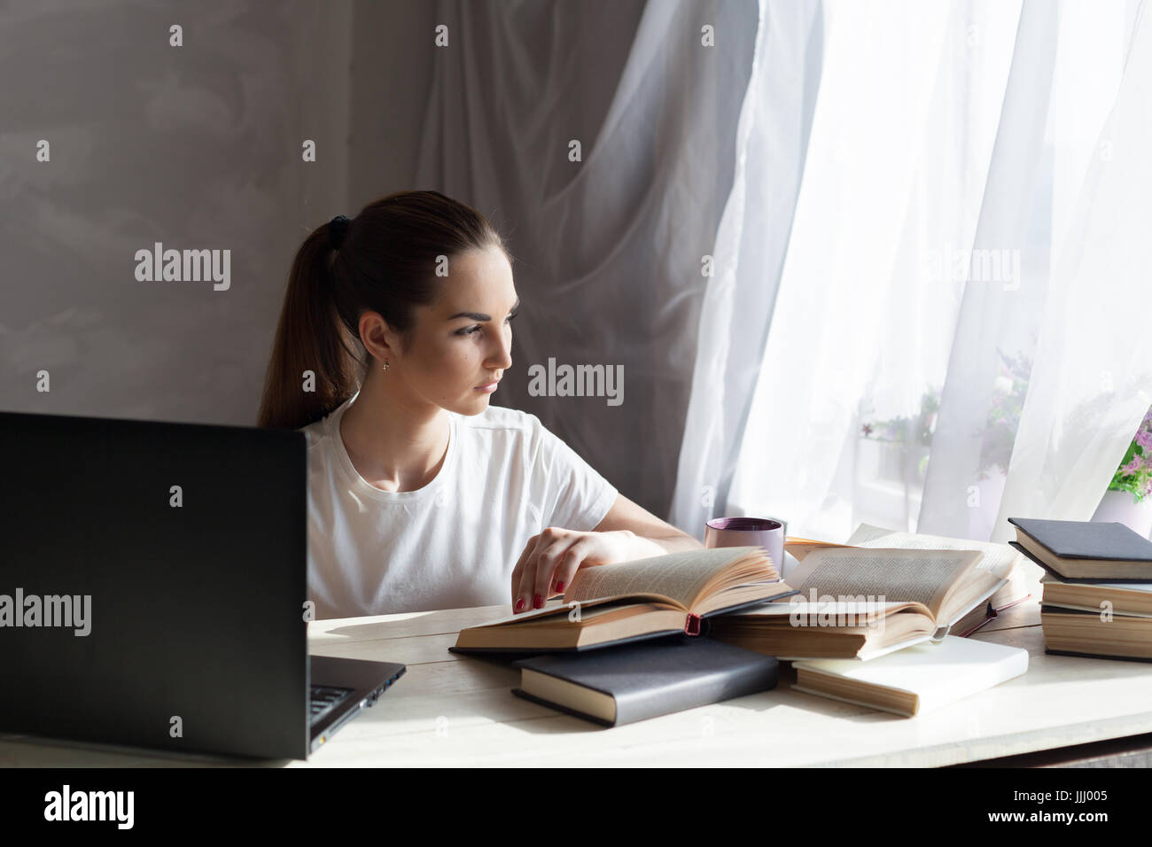 girl works at the computer reads books Stock Photo - Alamy