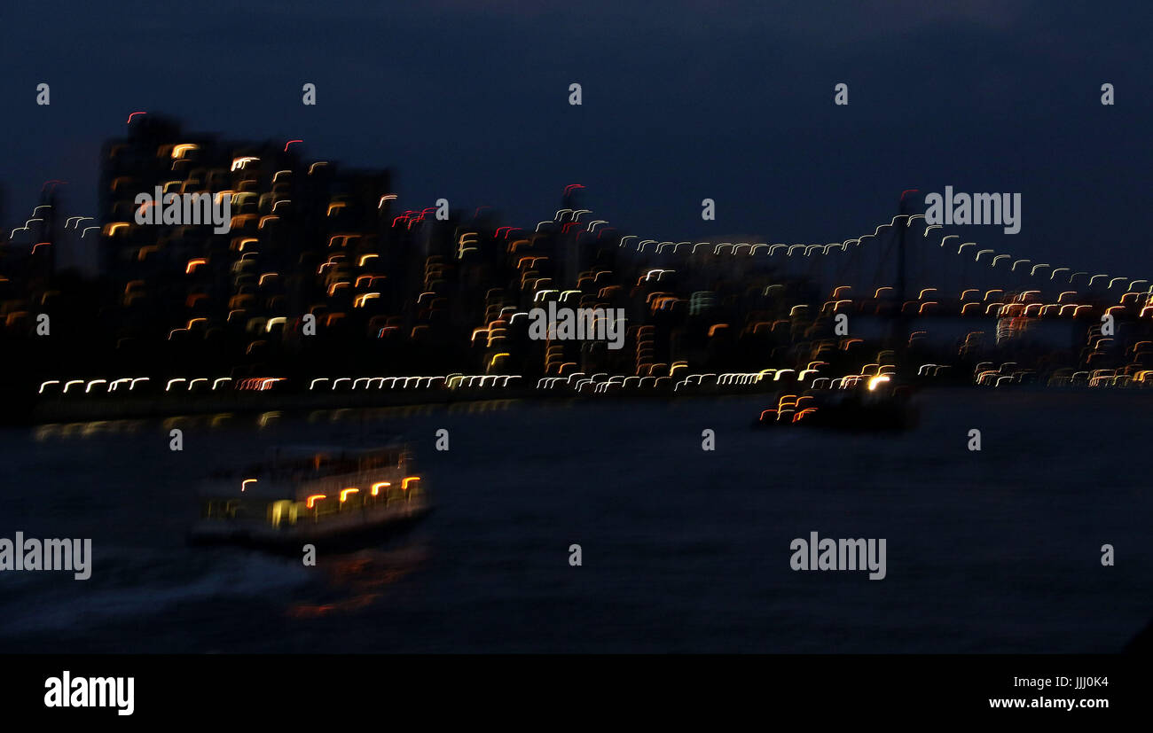 Slow shutter of East River with boat, bridge and city lights Stock ...