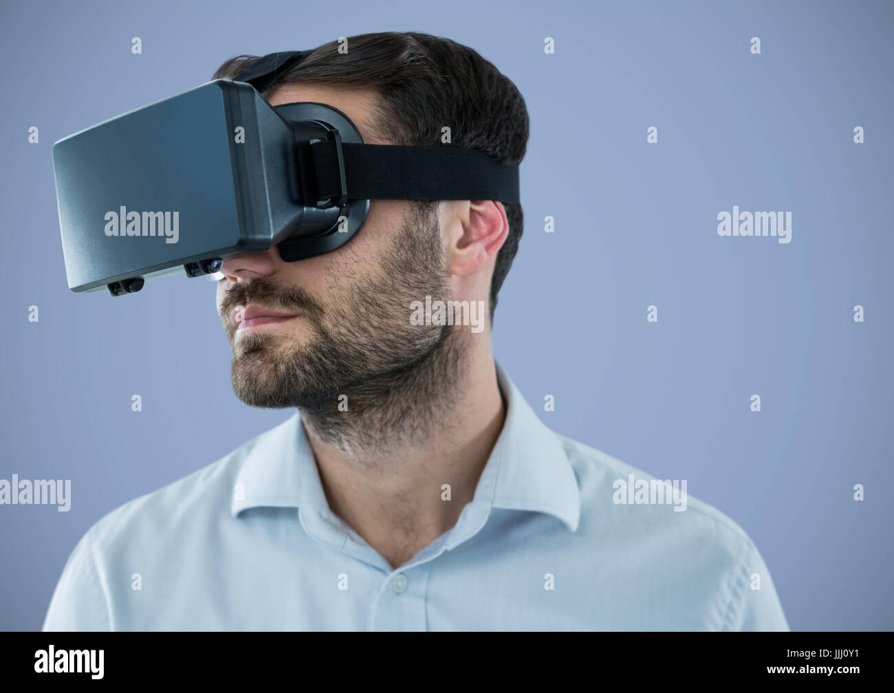 Man in virtual reality headset against purple background Stock Photo ...