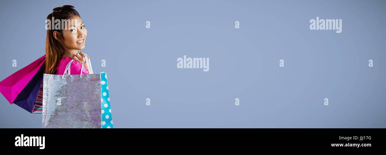 Shopper with bags looking over shoulder against purple background and ...