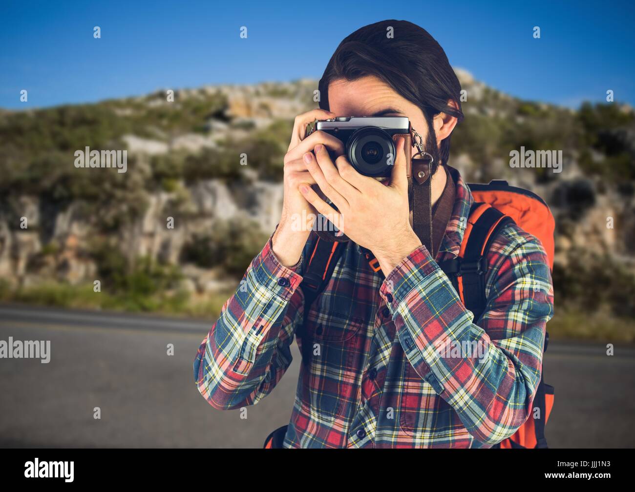 Millennial backpacker with camera against road and rock Stock Photo - Alamy