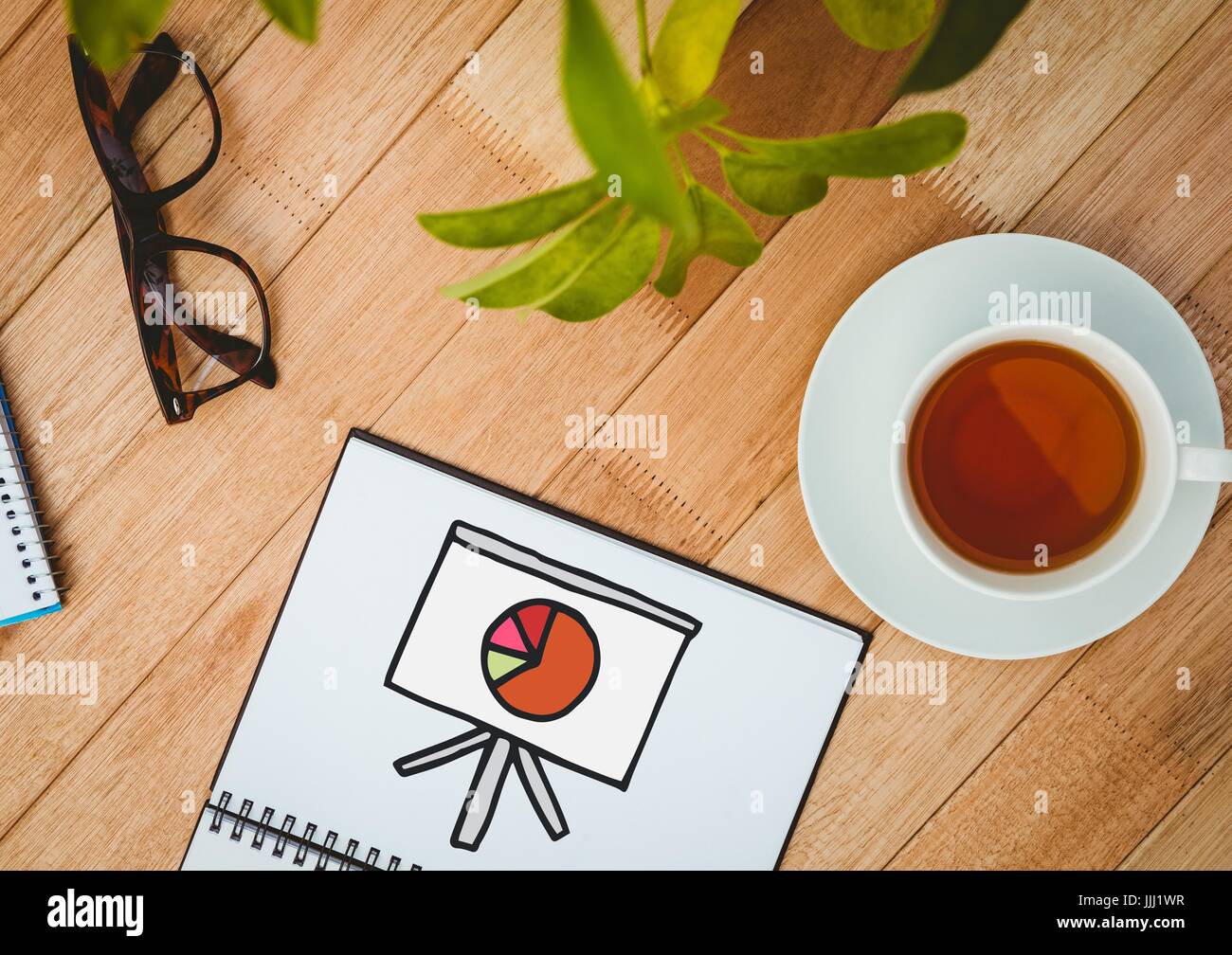 Chart doodle on notepad next to tea, plant and glasses Stock Photo - Alamy