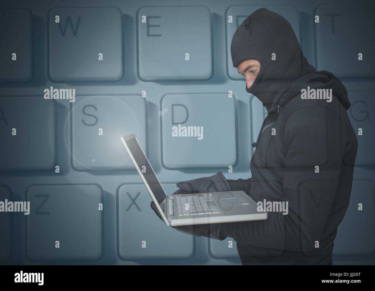 Hacker using a laptop in front of digital background of keyboard Stock ...